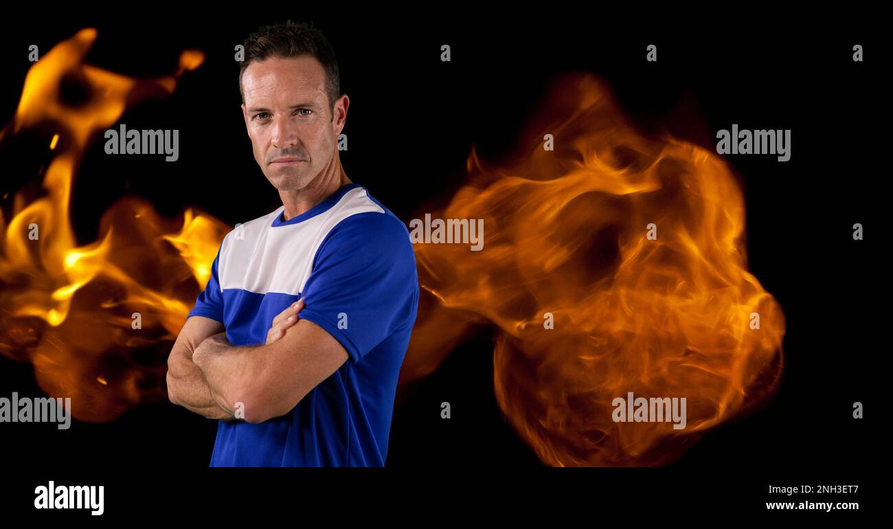 Composition of male basketball player with arms crossed over flames on ...