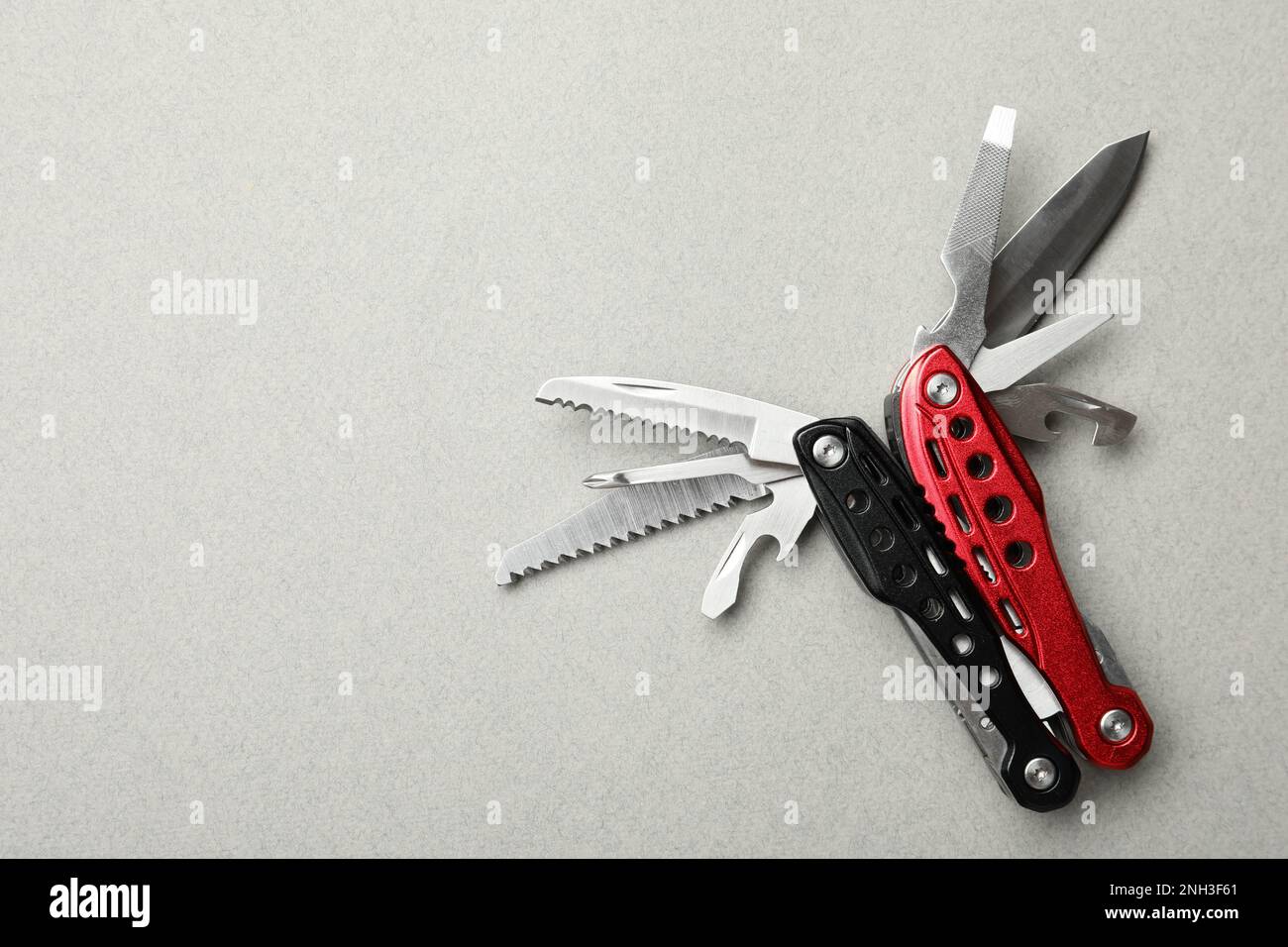 Compact portable multitool on light grey background, top view. Space ...