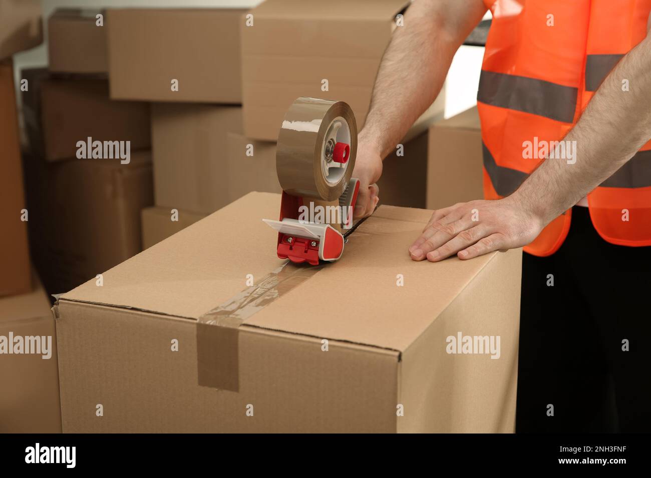 Worker taping cardboard box indoors, closeup view Stock Photo - Alamy