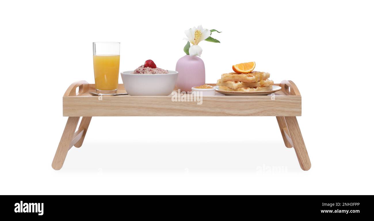 Wooden tray with delicious breakfast and beautiful flower on white ...