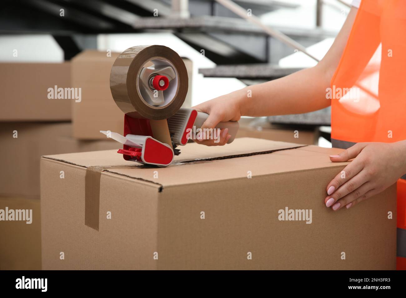 Worker taping cardboard box indoors, closeup view Stock Photo - Alamy