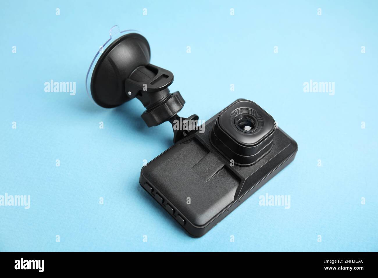 Modern car dashboard camera with suction mount on light blue background ...