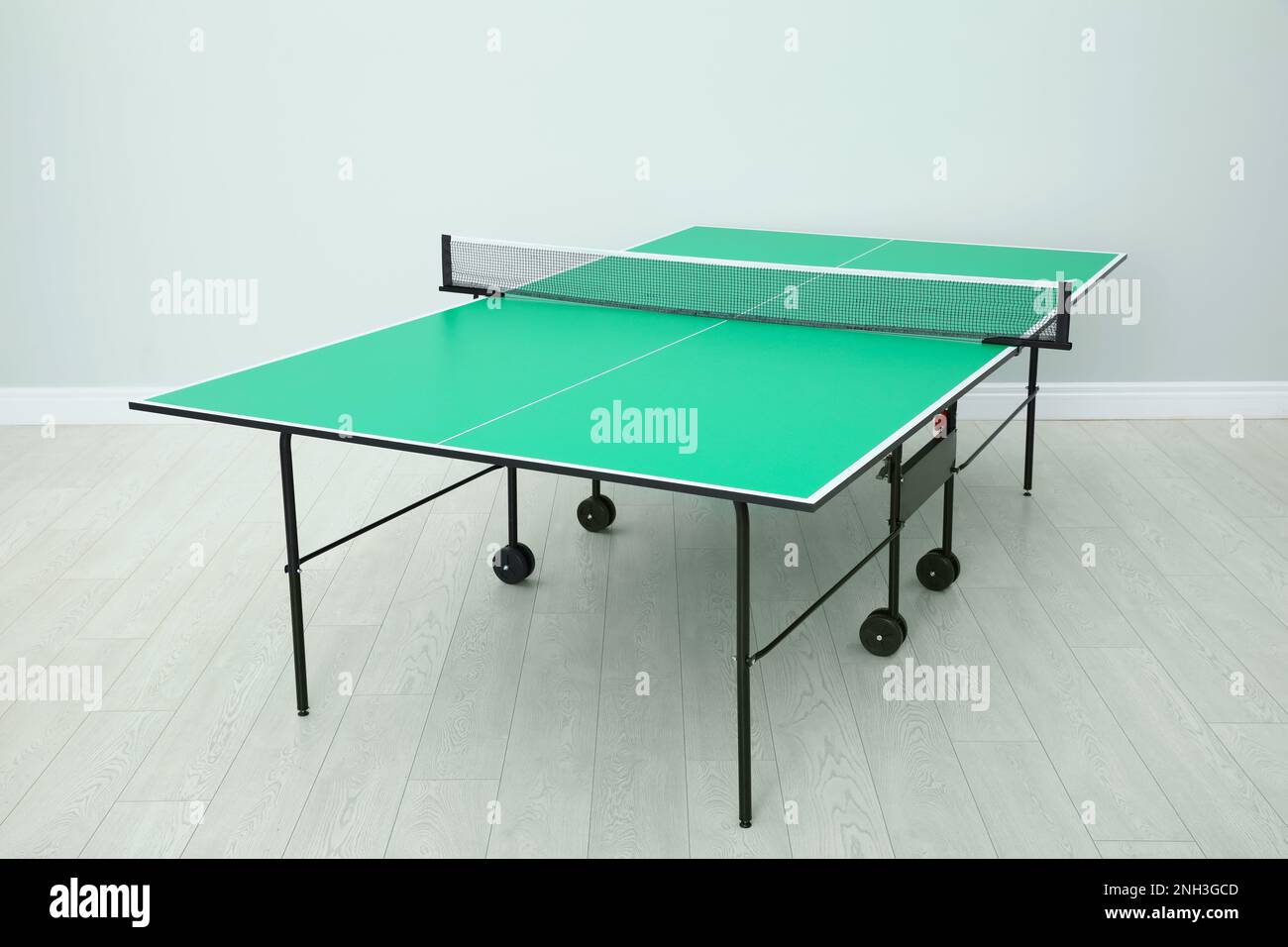 One green ping pong table with net indoors Stock Photo - Alamy