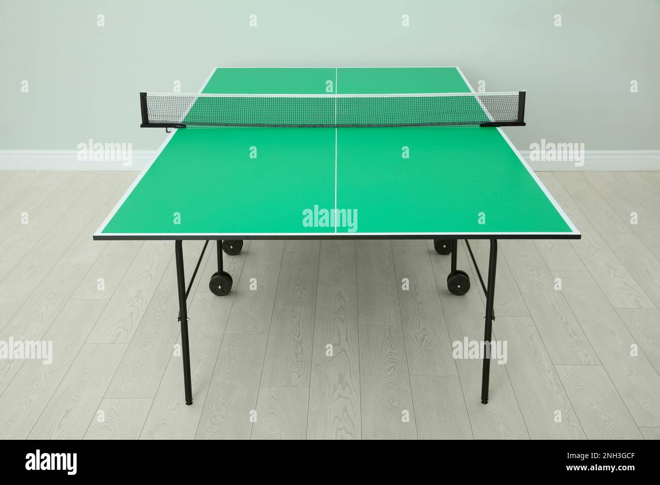 One green ping pong table with net indoors Stock Photo - Alamy