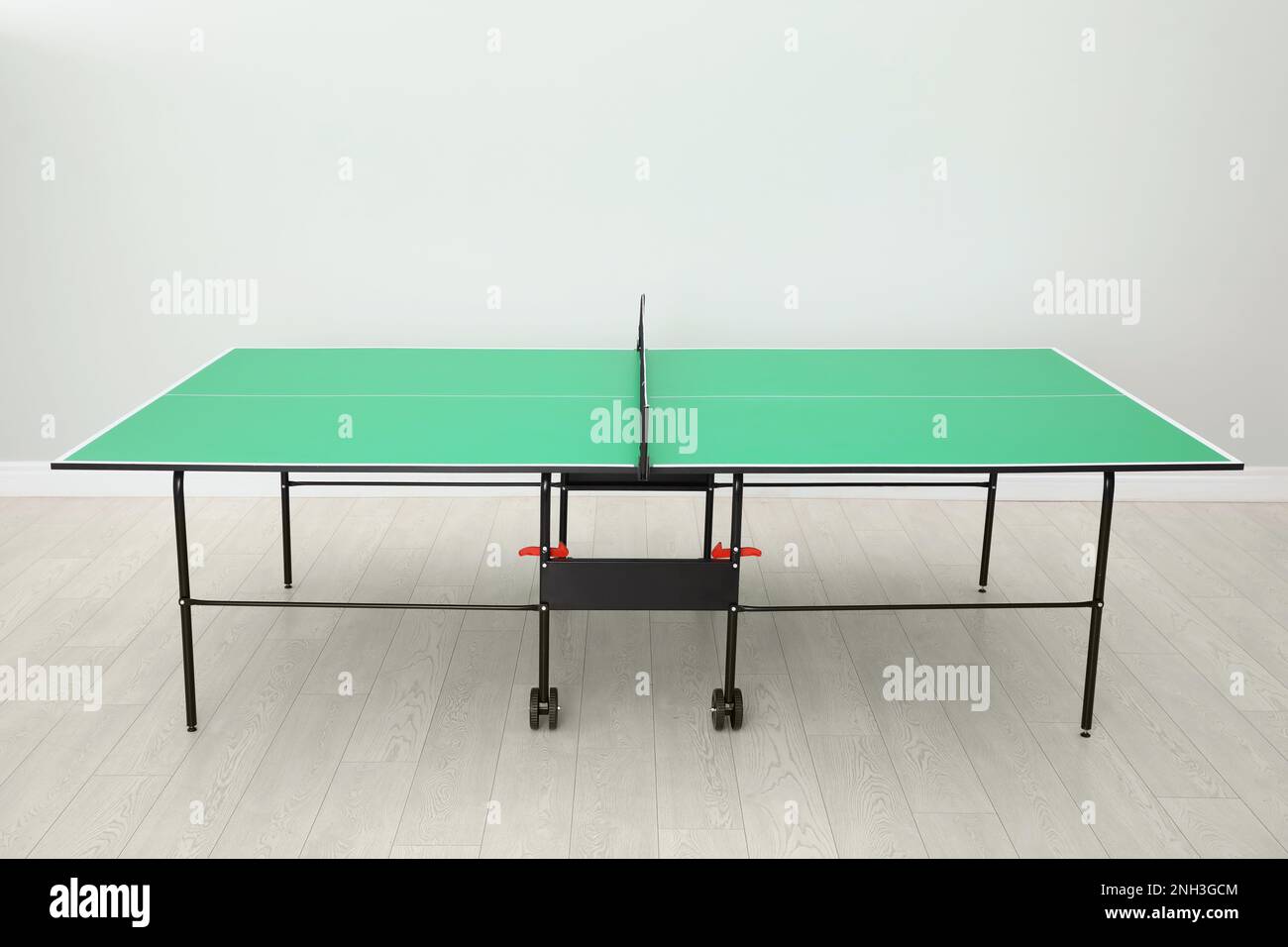 One green ping pong table with net indoors Stock Photo - Alamy