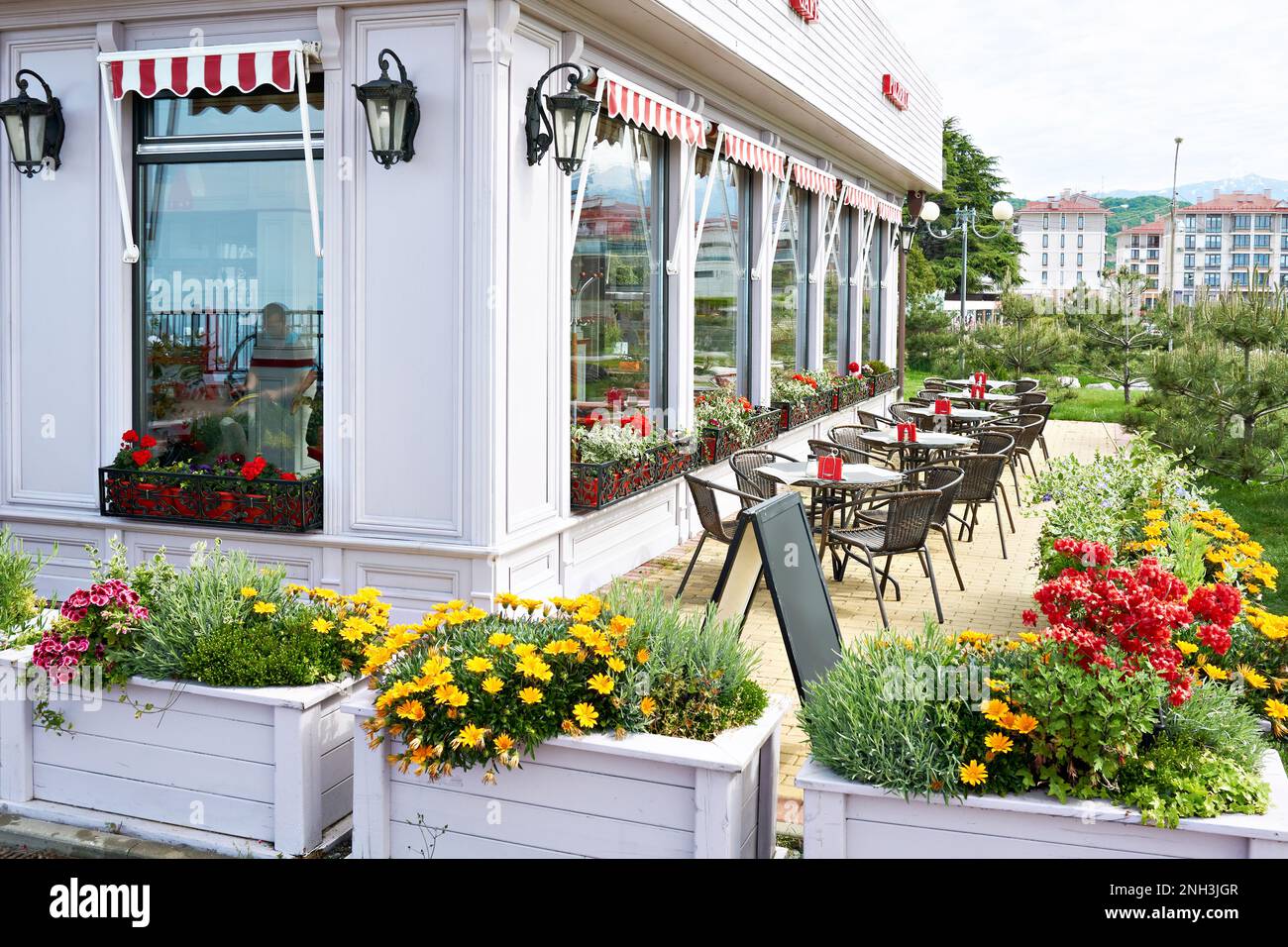 Flowers and tables at an outdoor summer cafe Stock Photo - Alamy
