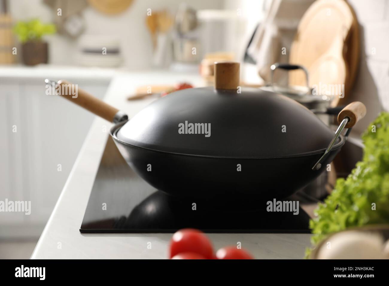 Frying pan with lid on cooktop in kitchen Stock Photo - Alamy