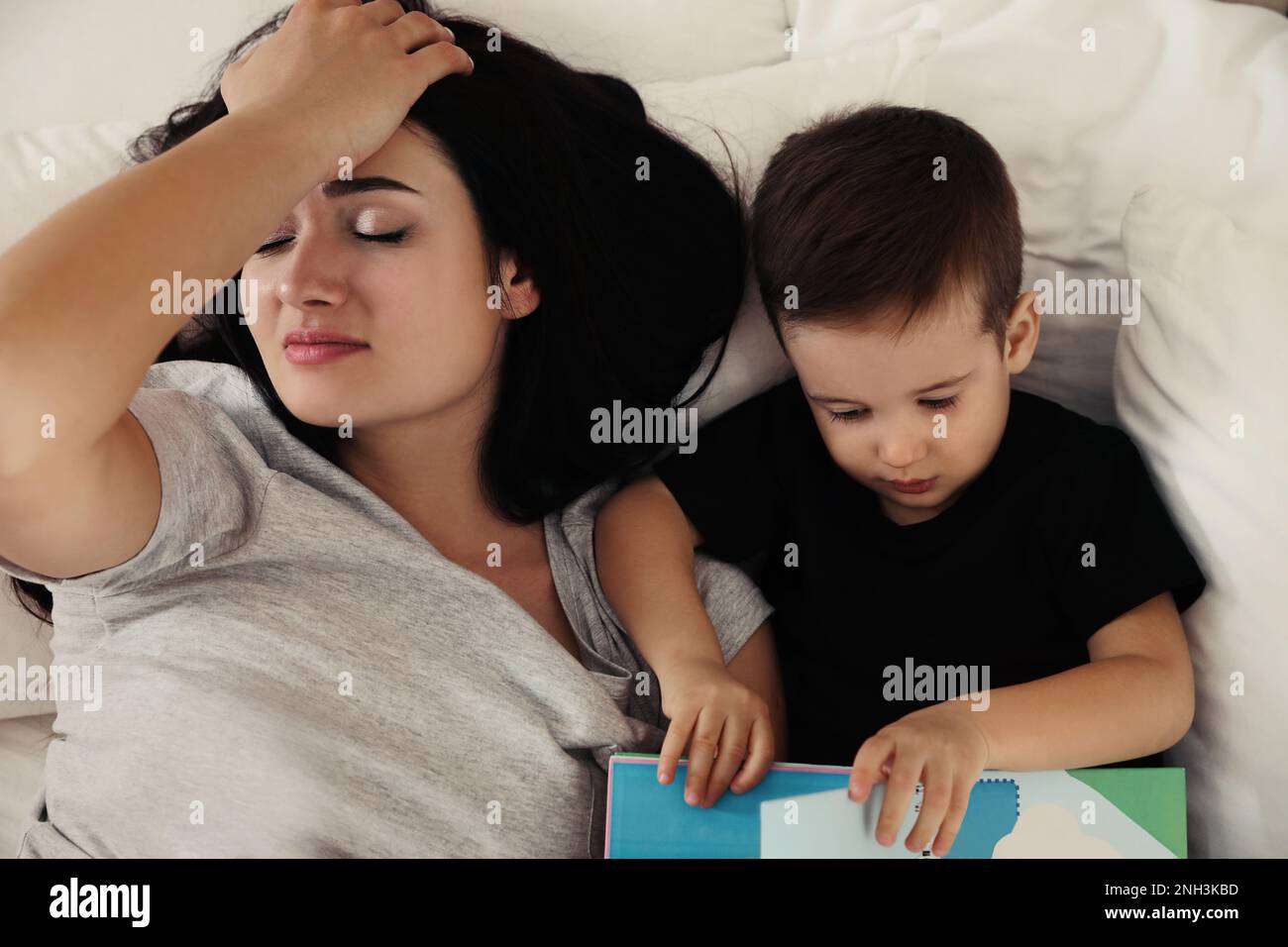 Depressed single mother with child in bed at home, above view Stock ...