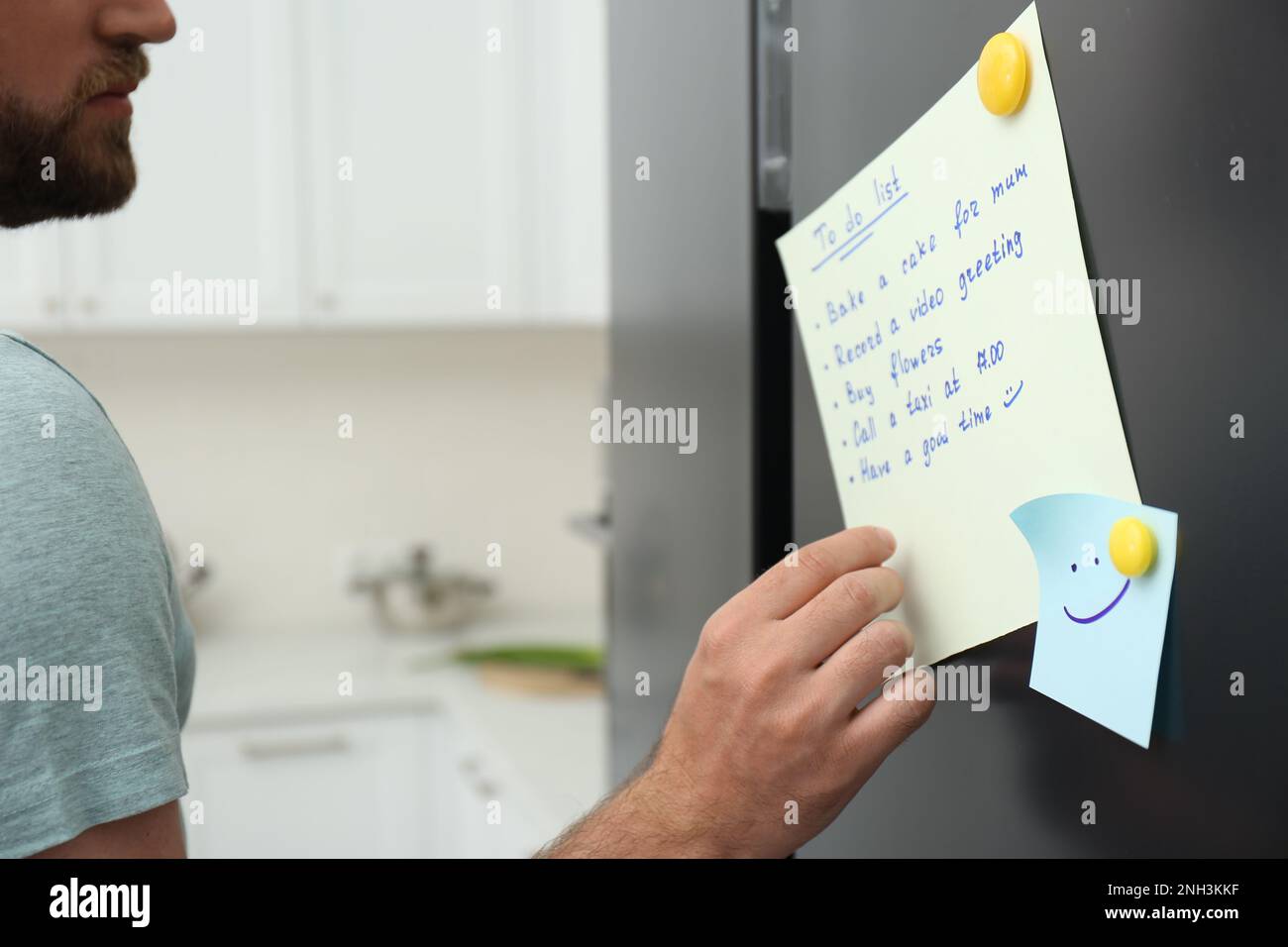 Man checking to do list on fridge in kitchen, closeup Stock Photo - Alamy