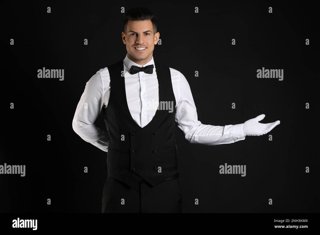 Handsome butler in elegant uniform on black background Stock Photo - Alamy