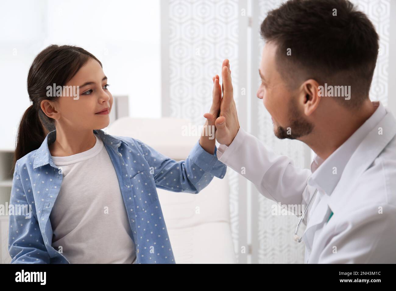 Pediatrician giving high five to little girl in hospital Stock Photo ...