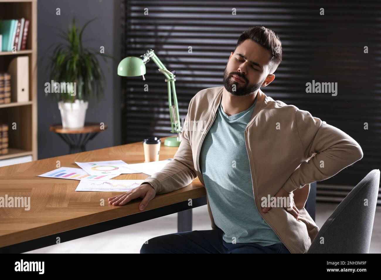 Man suffering from back pain in office. Bad posture problem Stock Photo ...