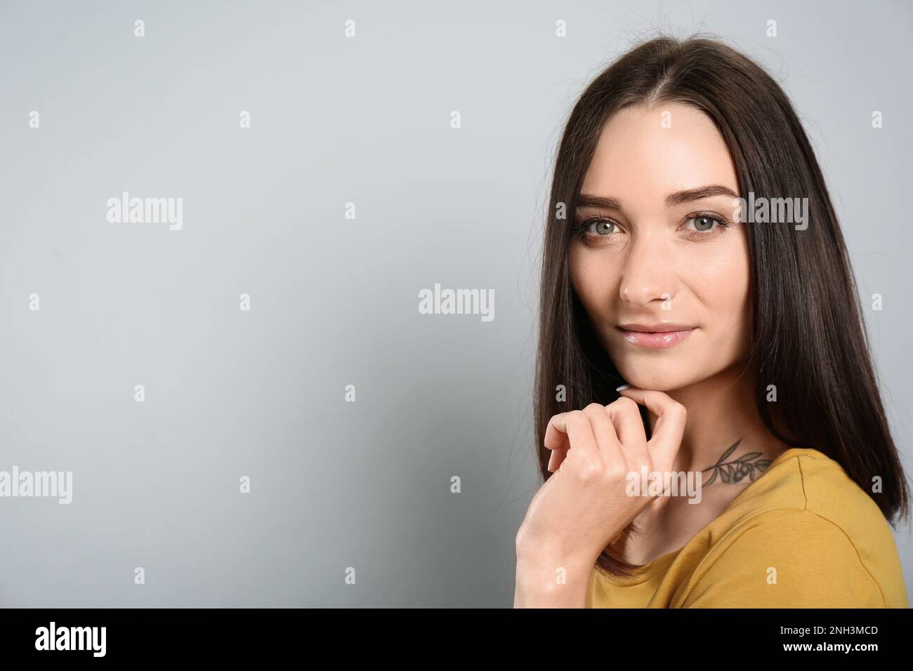 Portrait of pretty young woman with gorgeous chestnut hair on light ...