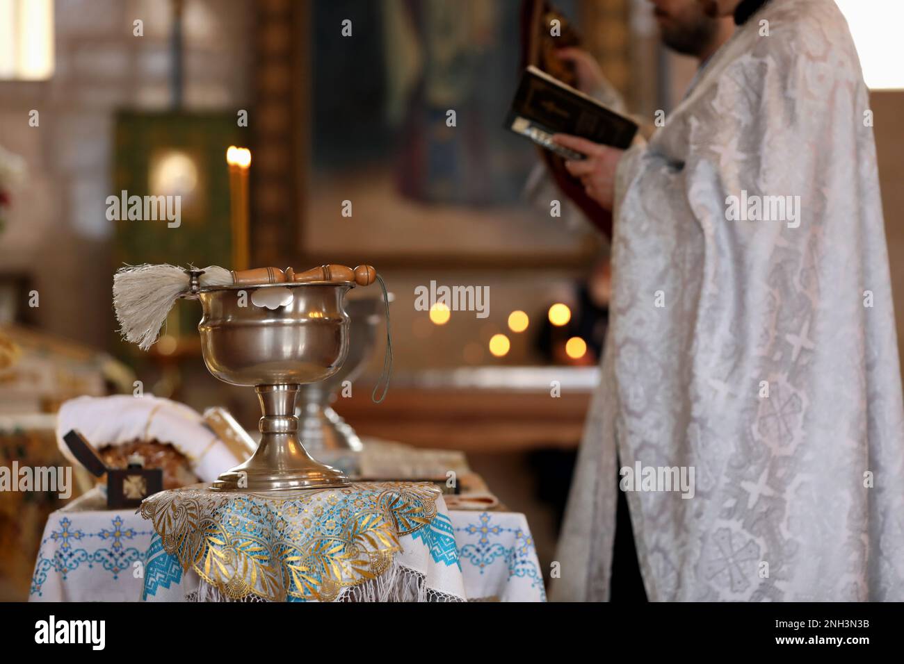 MYKOLAIV, UKRAINE - FEBRUARY 27, 2021: Priest conducting baptism ...