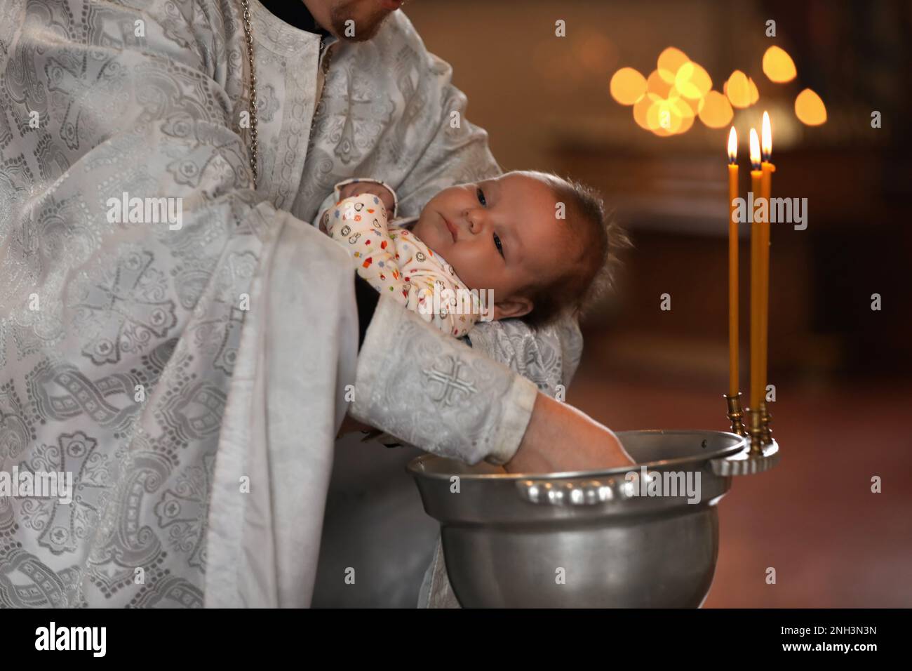 MYKOLAIV, UKRAINE - FEBRUARY 27, 2021: Priest holding baby in ...