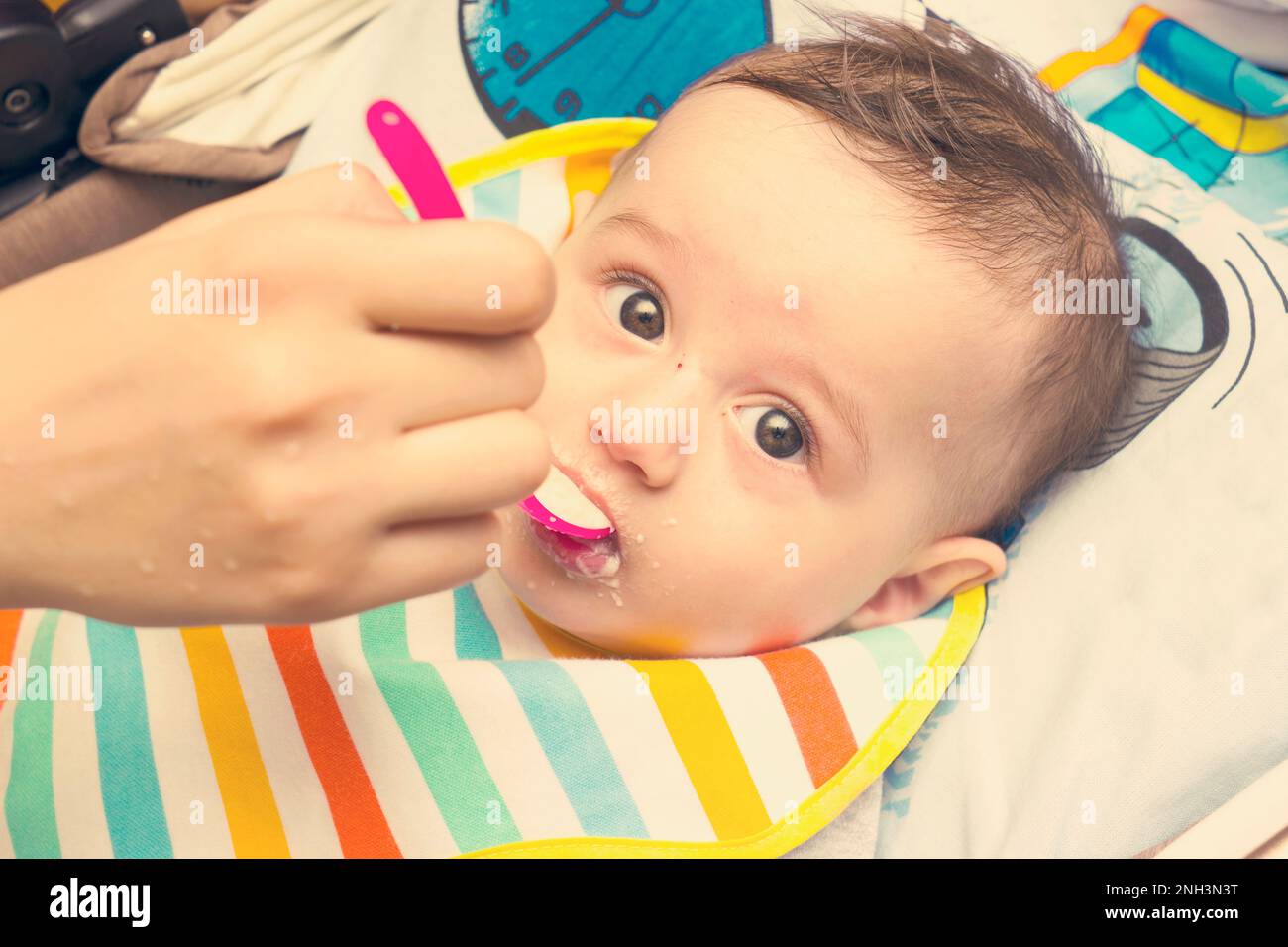 Woman's hand feeding food to little baby boy.New born baby boy wearing ...