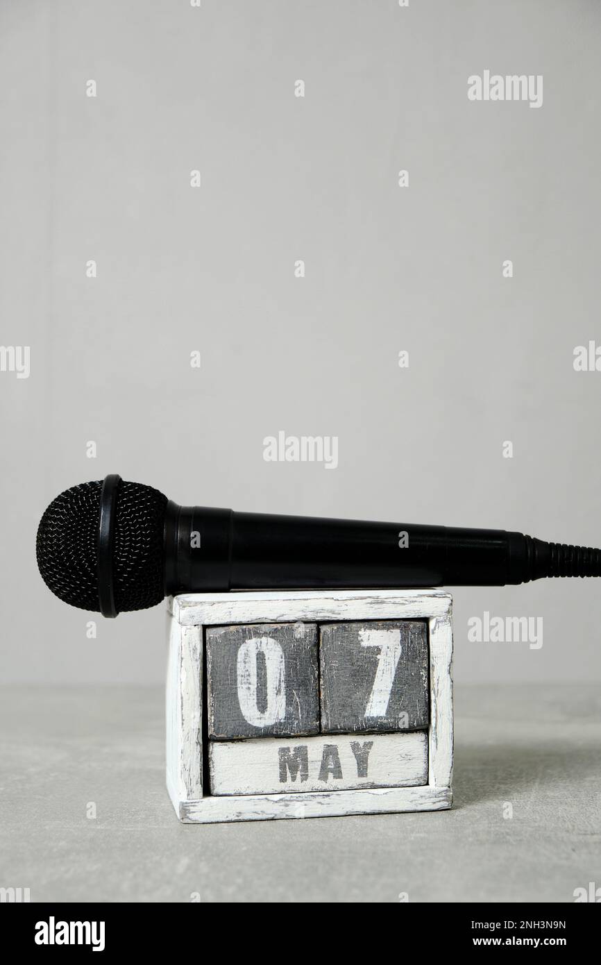May 07, wooden calendar and black microphone gray background.Concept ...
