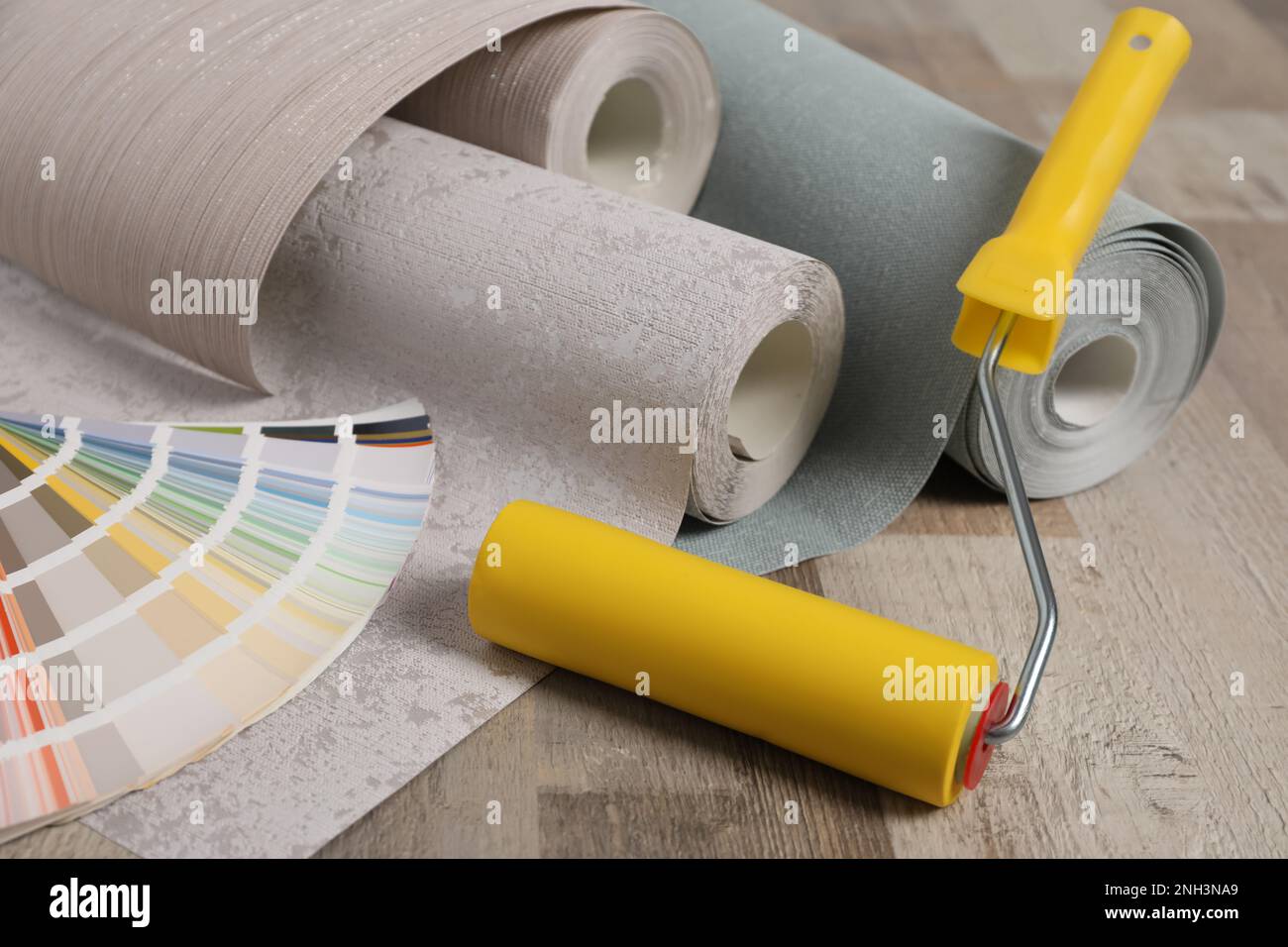 Wall paper rolls, color palette and tool on wooden floor Stock Photo ...