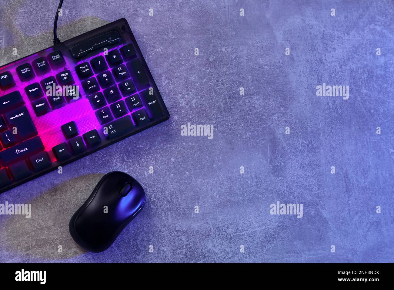 Modern RGB keyboard and mouse on grey table, flat lay. Space for text ...