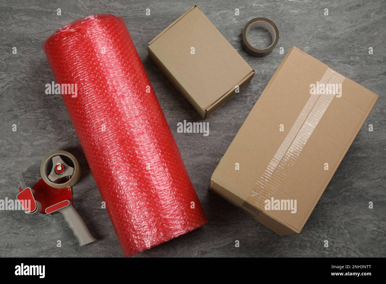 Flat lay composition with bubble wrap roll on grey background Stock ...