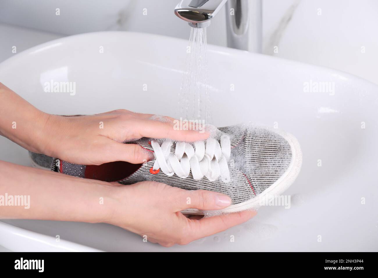 Woman washing sport shoe in sink, closeup Stock Photo - Alamy