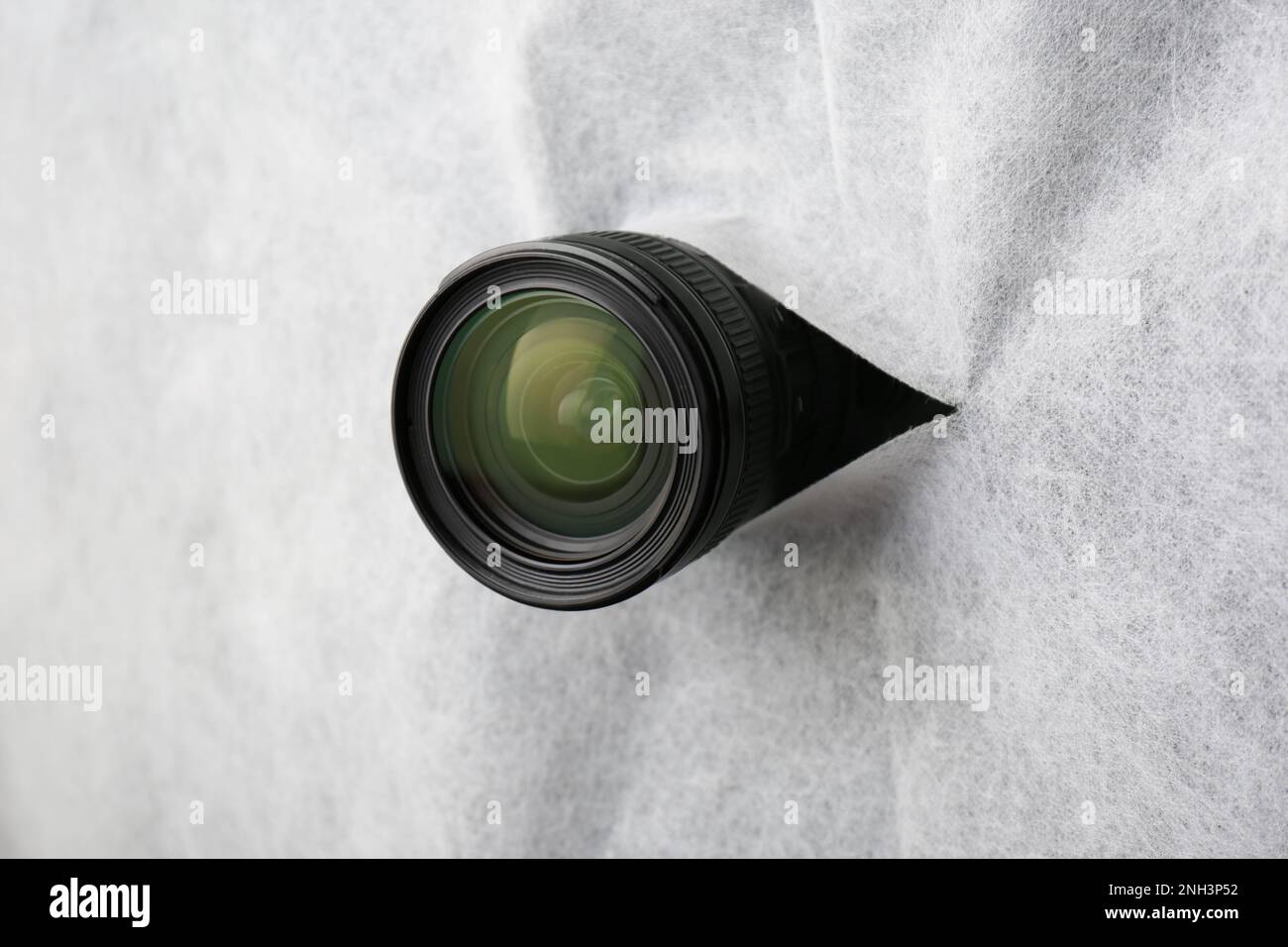 Hidden camera lens through torn hole in white fabric Stock Photo - Alamy