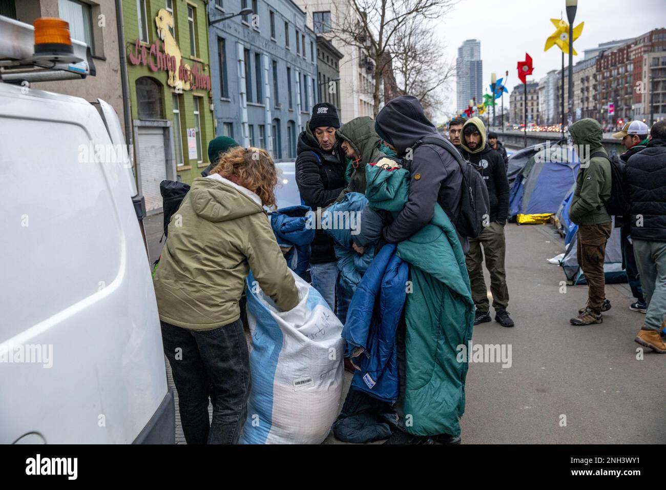 Illustration shows volunteers handing out blankets at the tents in ...
