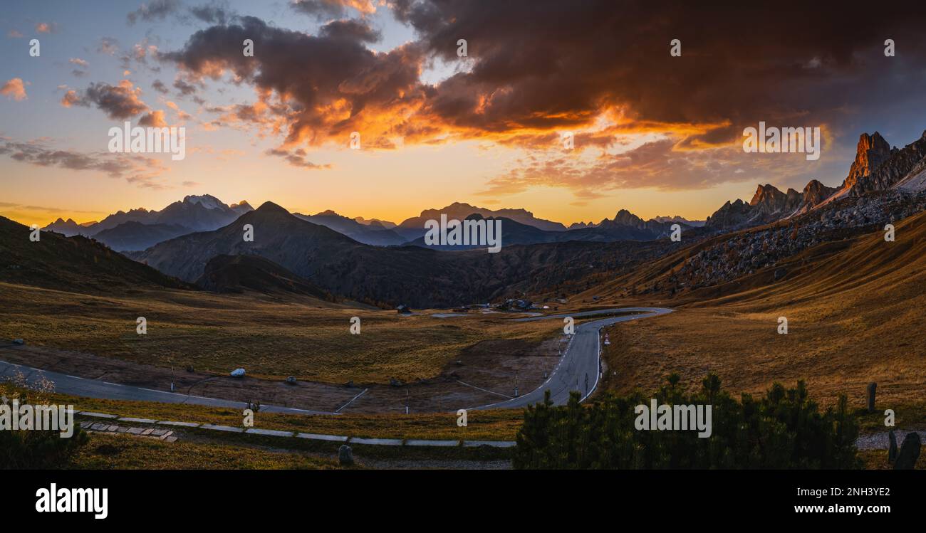 Sun glow in evening hazy sky. Italian Dolomites mountain silhouettes ...