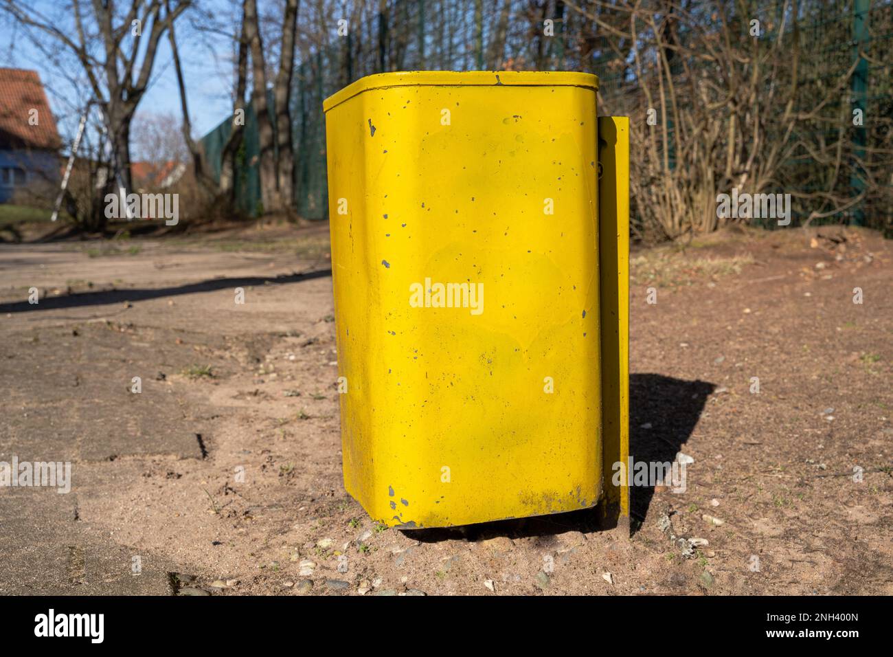 Square yellow trash can in the park Stock Photo - Alamy