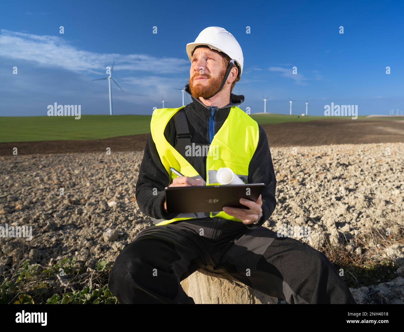 engineer with tablet and laptop working in a wind turbine park Stock ...