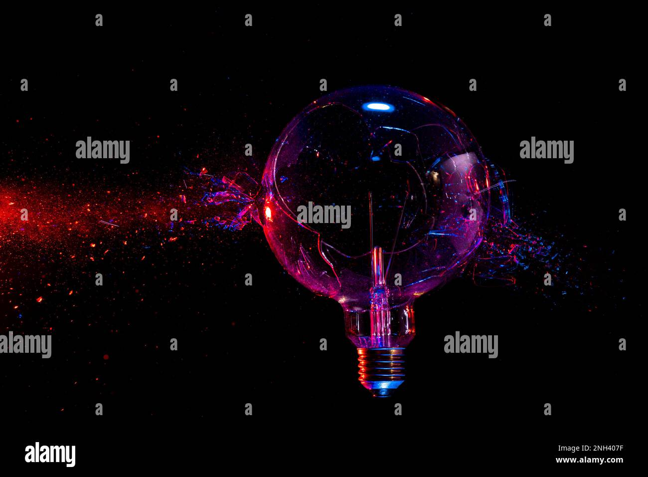 large filament bulb breaks and creates fragments. black background ...