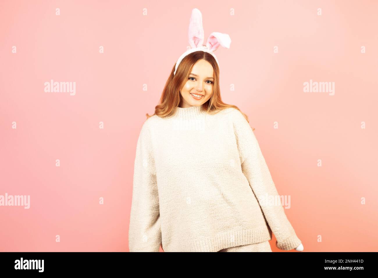 Beautiful girl in rabbit ears on a pink background laugh, Easter ...