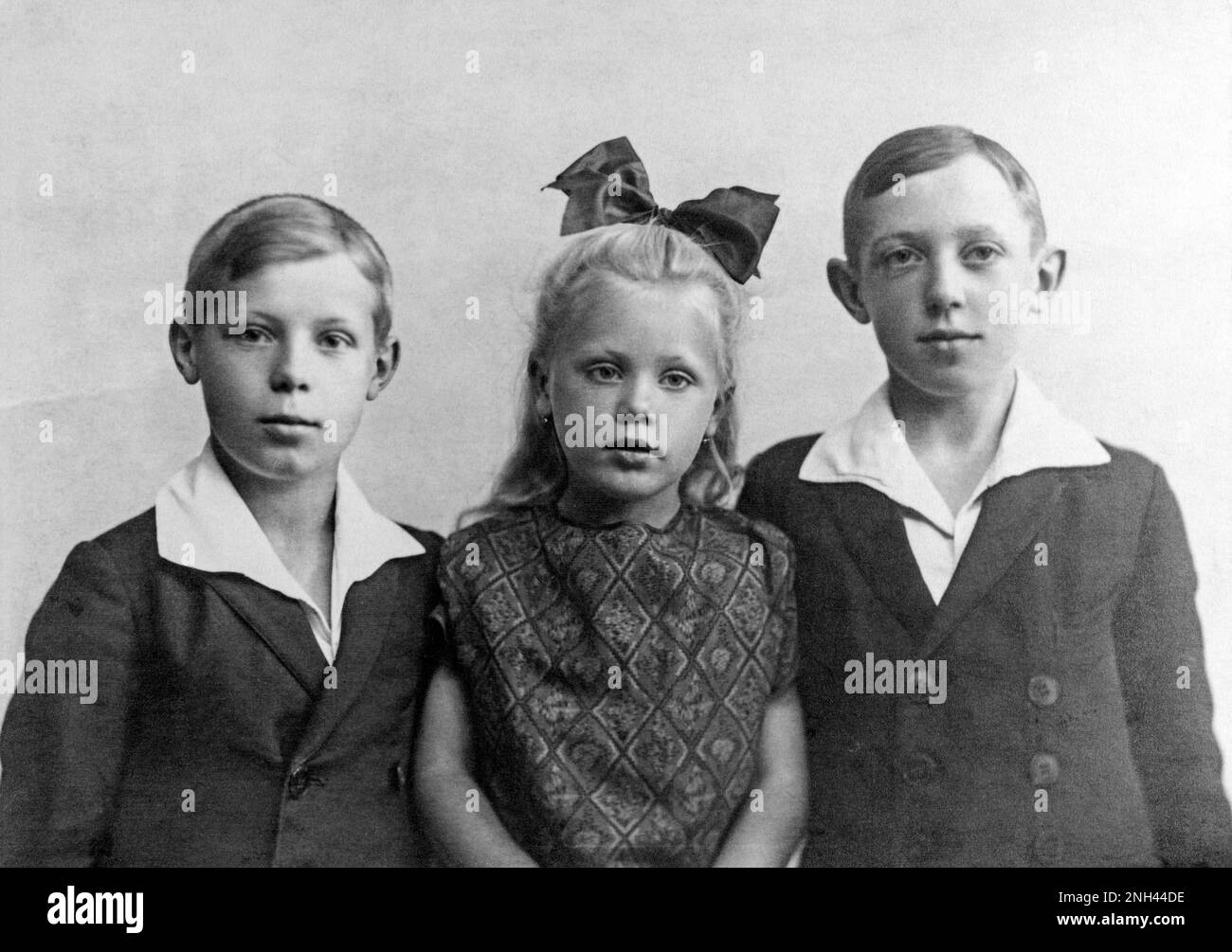 Portrait of two brothers and their sister looking into the camera ...