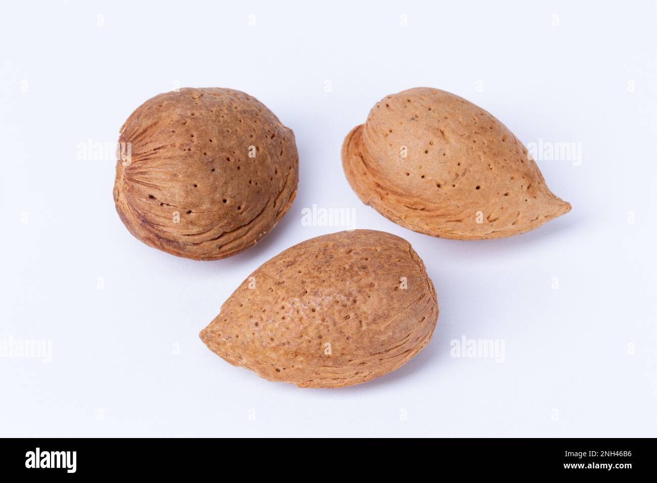 Three Almond nuts on a white background Stock Photo - Alamy