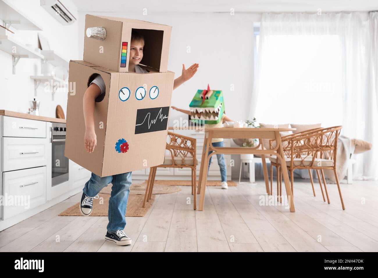 Little boy in cardboard robot costume playing at home Stock Photo - Alamy