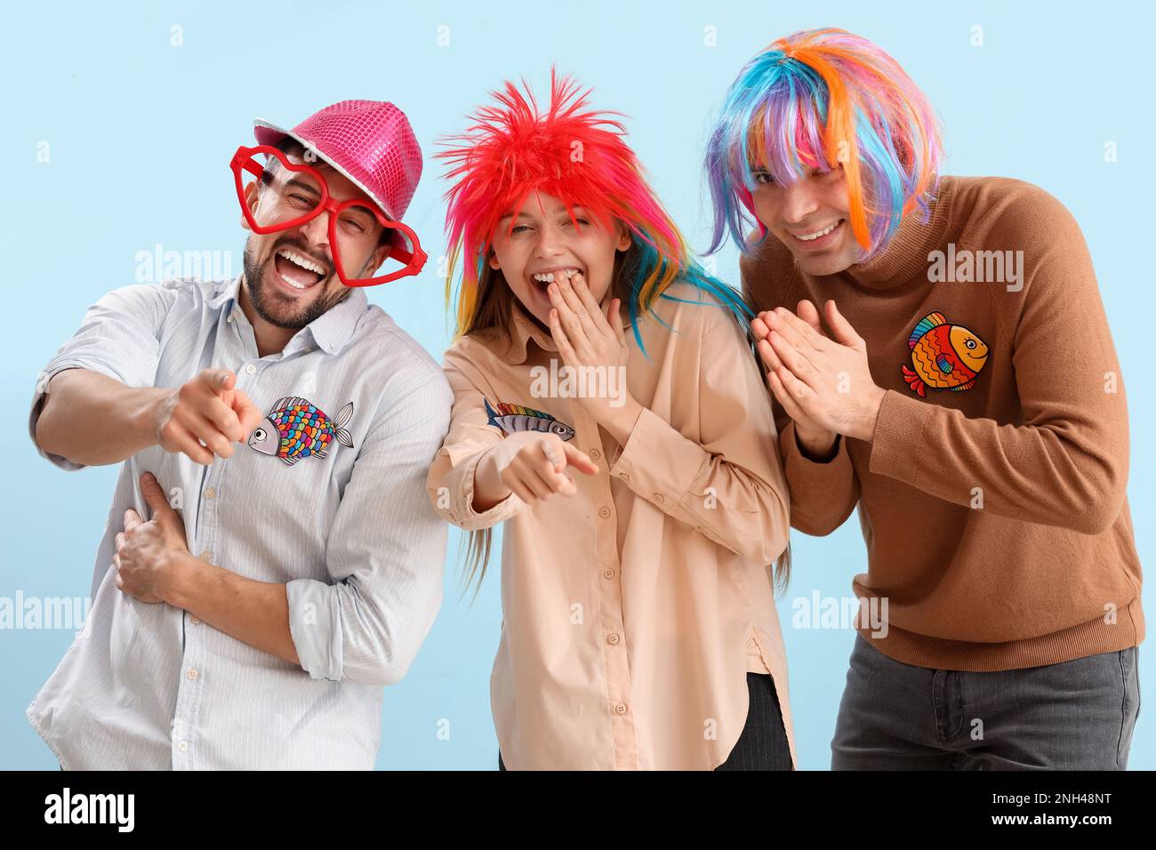 Business colleagues in funny disguise laughing on blue background ...