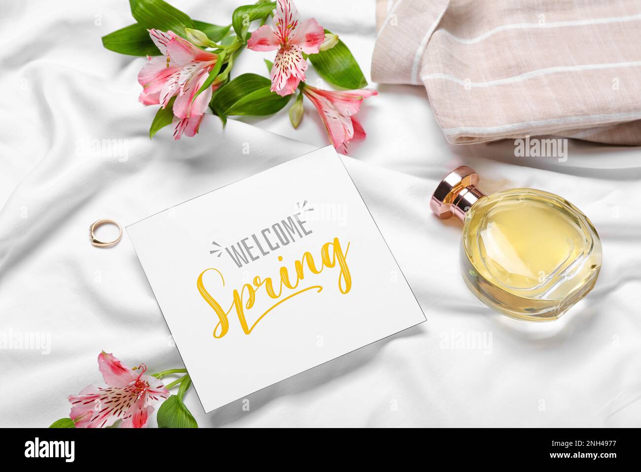 Card with text HELLO SPRING, bottle of perfume, alstroemeria flowers ...