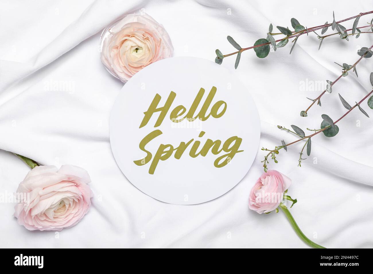 Card with text HELLO SPRING, eucalyptus branch and ranunculus flowers ...