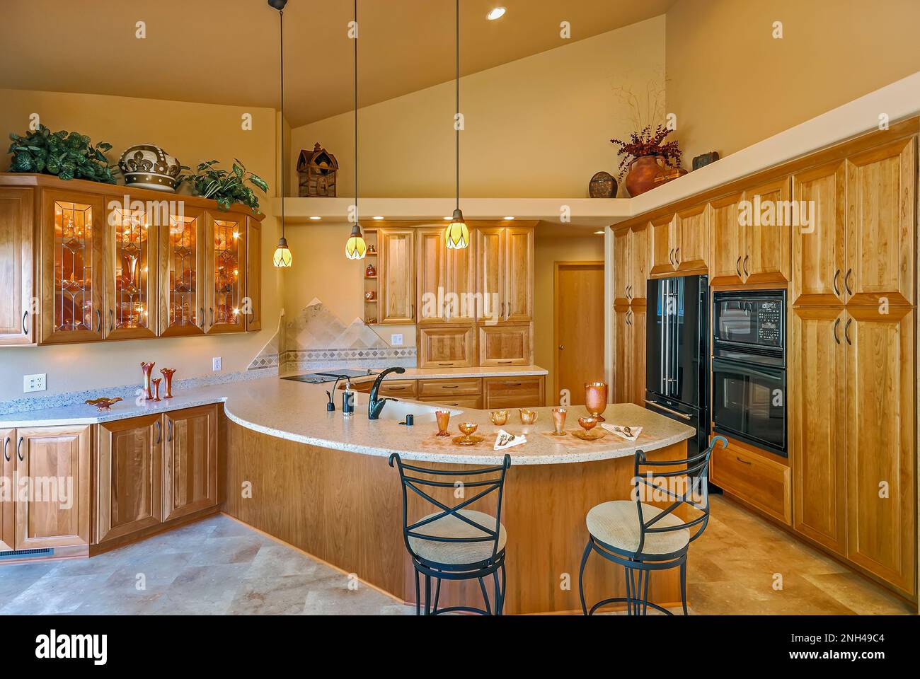 Views of a semi-circular countertop with 2 chairs and wood cabinets in ...