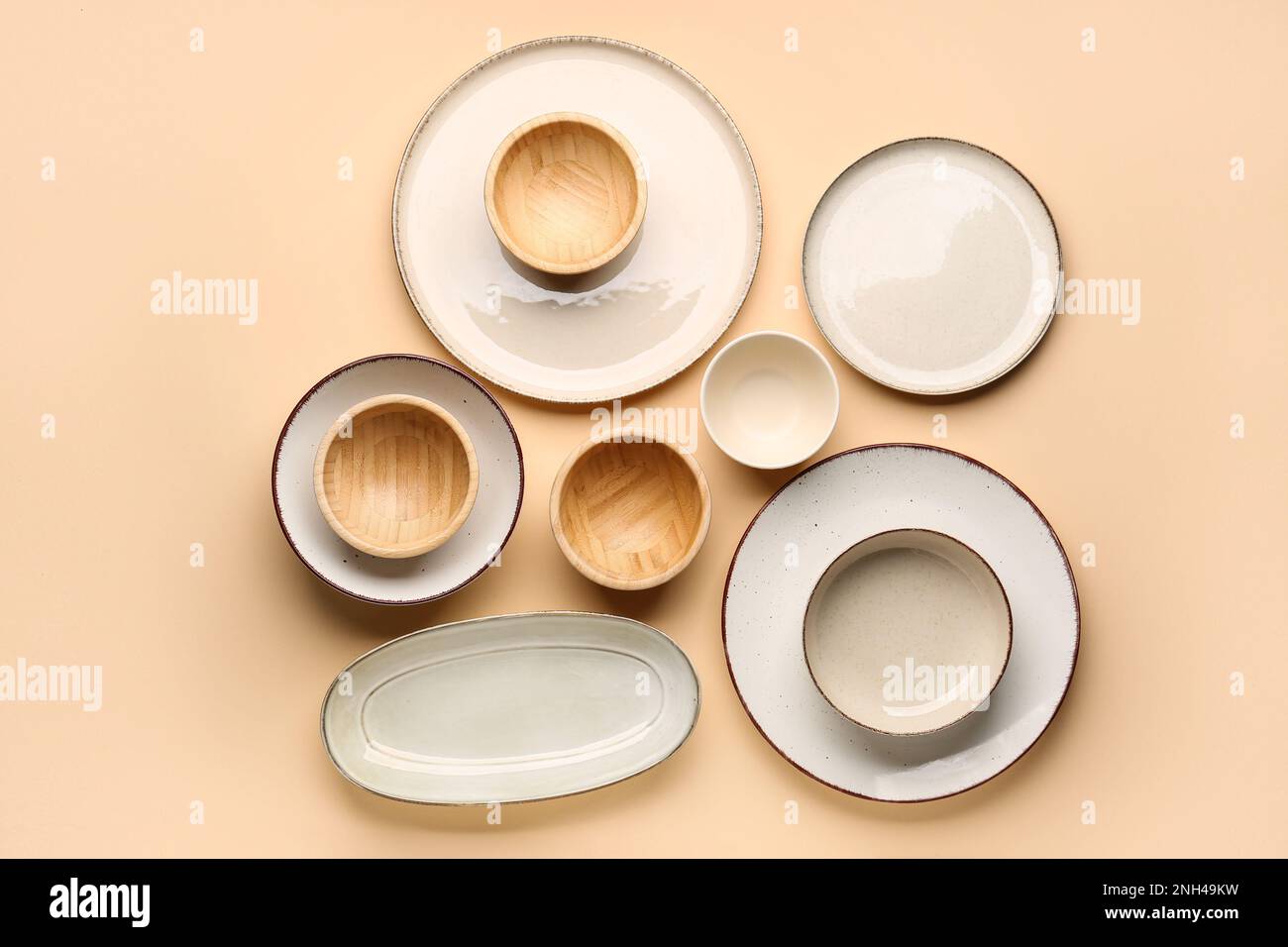 Set of plates and bowls on beige background Stock Photo - Alamy