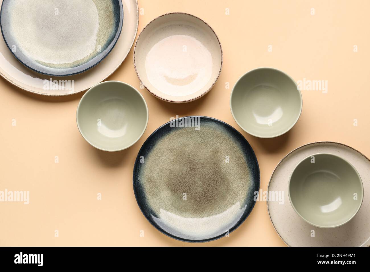 Set of plates and bowls on beige background Stock Photo - Alamy