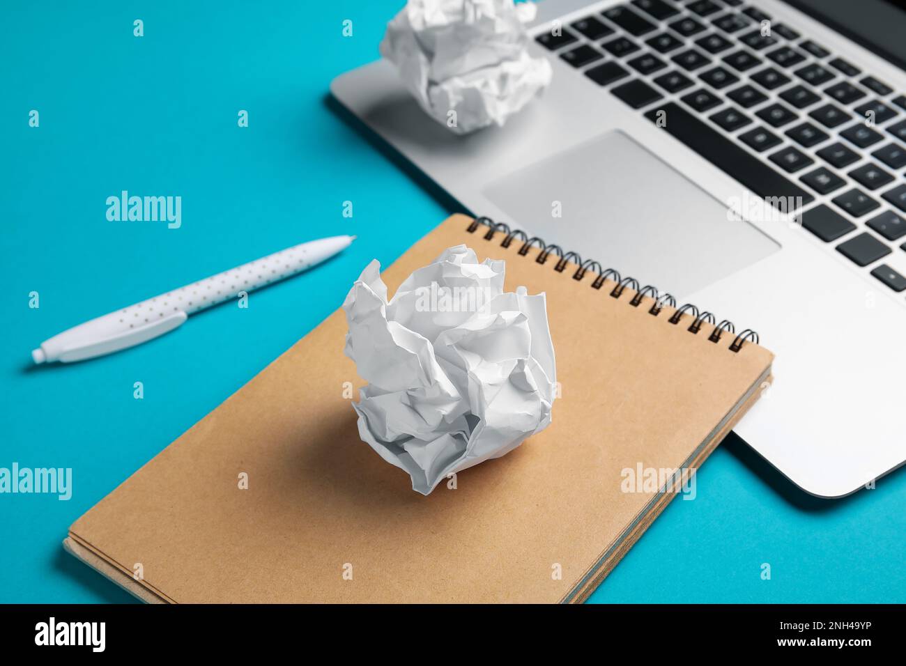 Notebook, pen, laptop and crumpled paper balls on color background ...