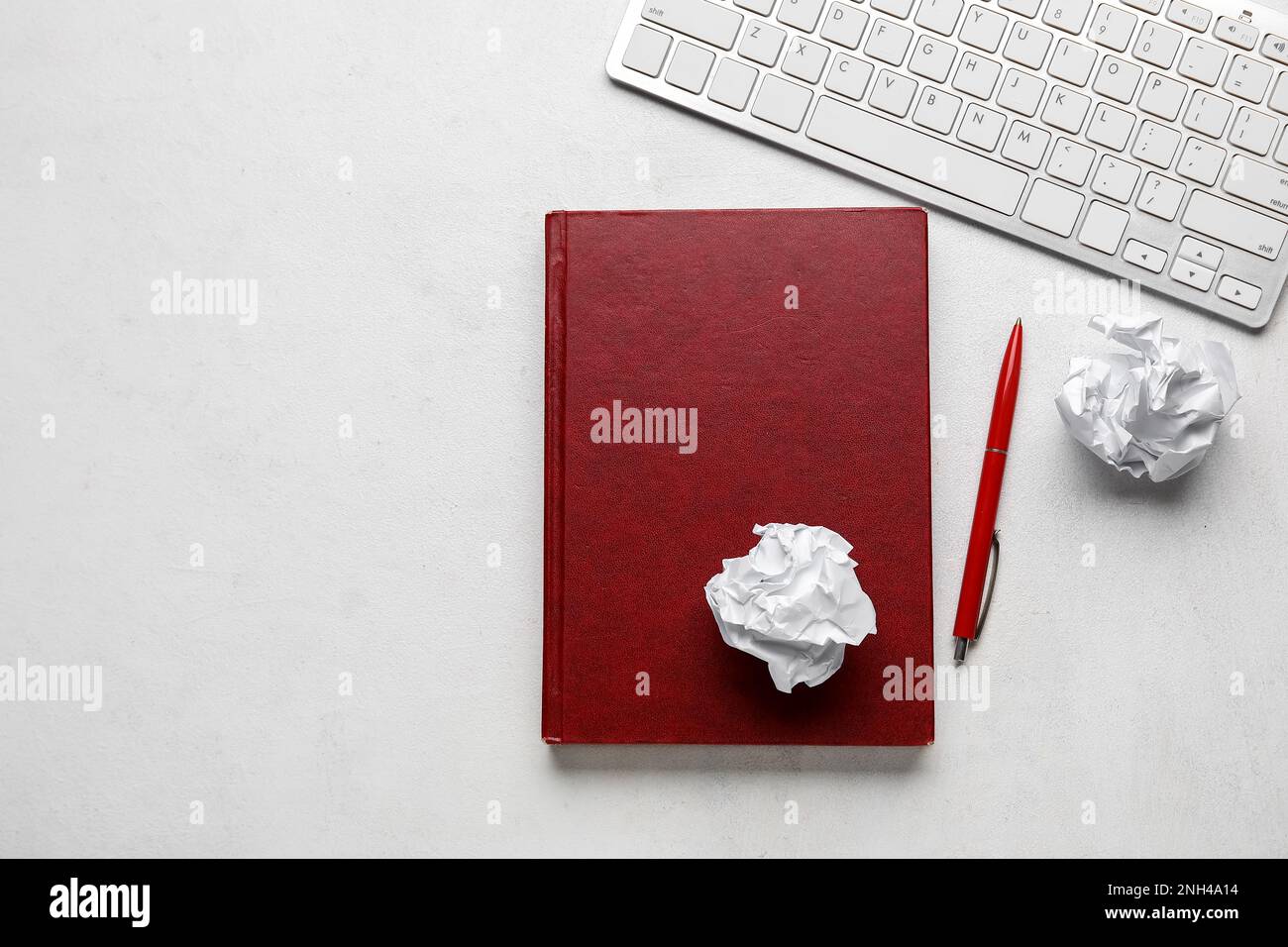 Book, crumpled paper balls, pen and keyboard on light background. World ...