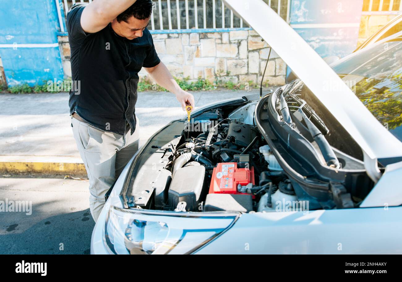Man checking the oil in his vehicle. Person checking the oil level of ...
