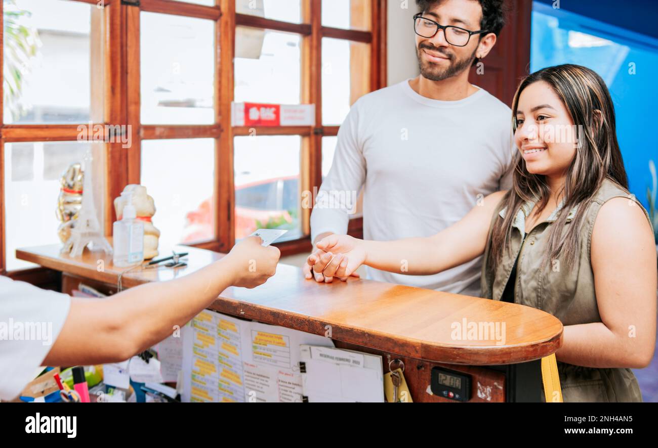 Couple receiving hotel room keys. Young couple receiving card key at a ...