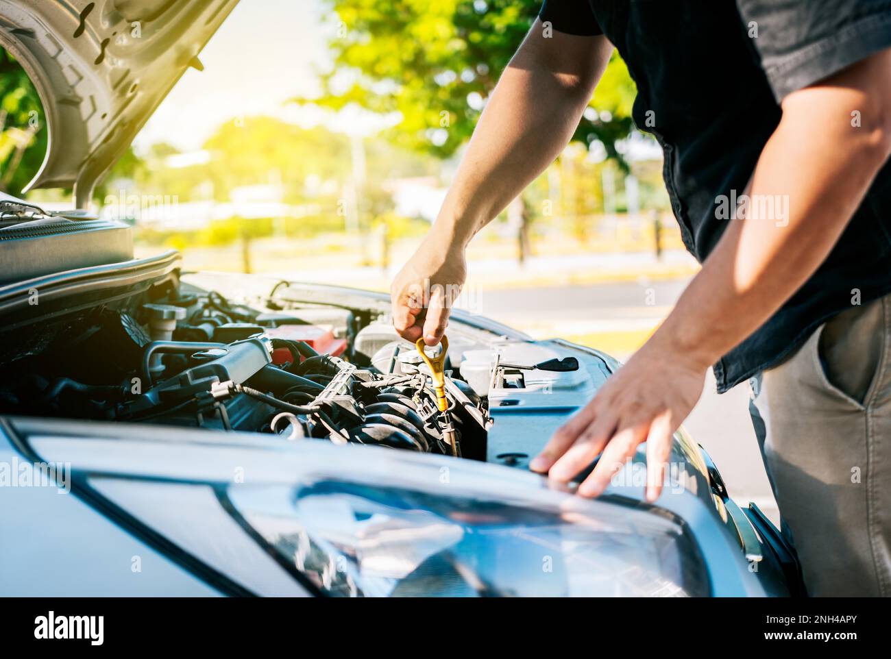 Driver hand inspecting car oil level. Man hand checking oil to car with ...