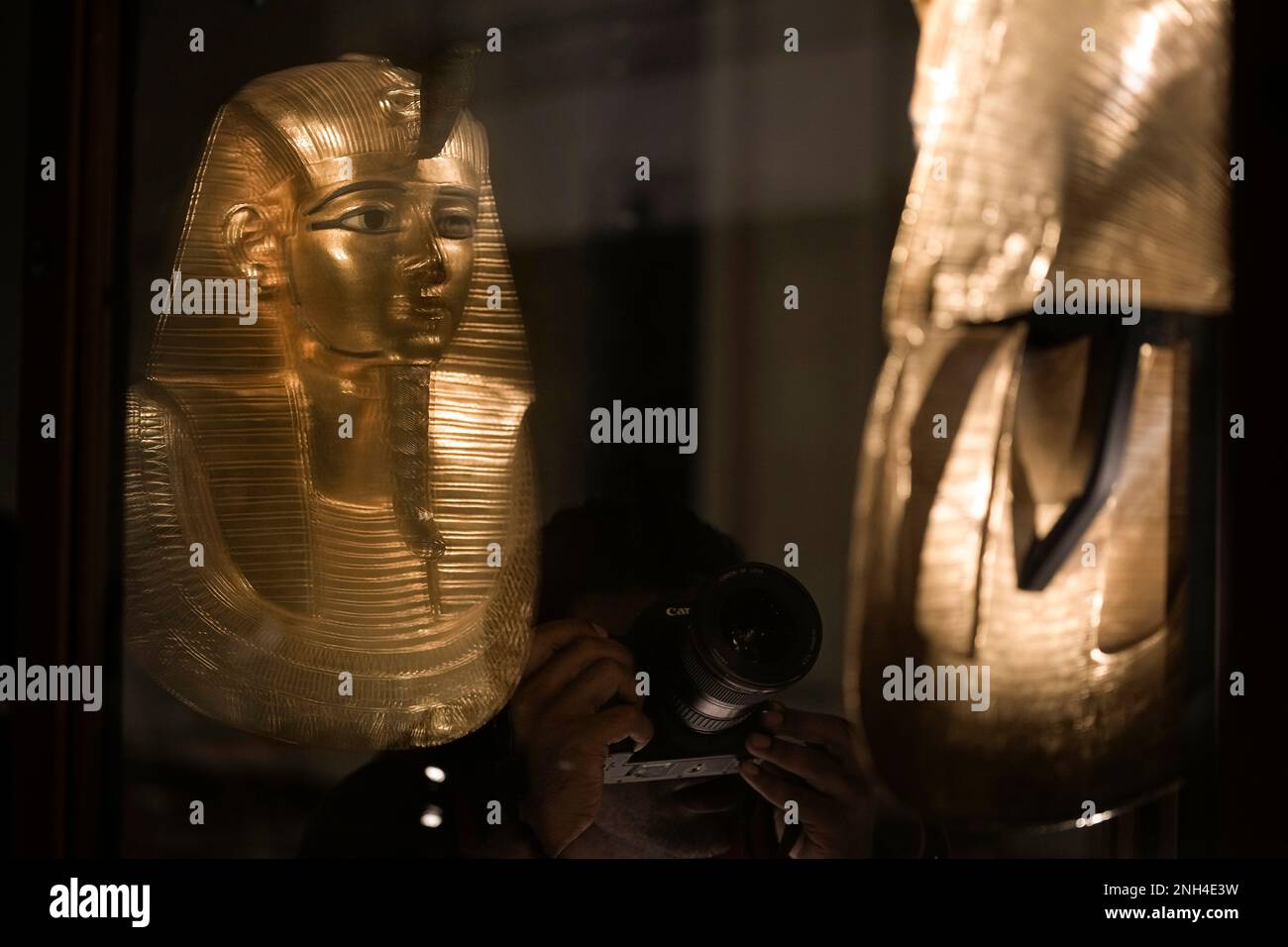 A visitor films a recently displayed golden funerary mask of king ...