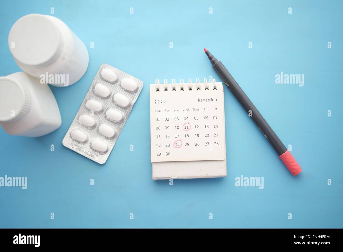 medical pill container and calendar on color background Stock Photo - Alamy