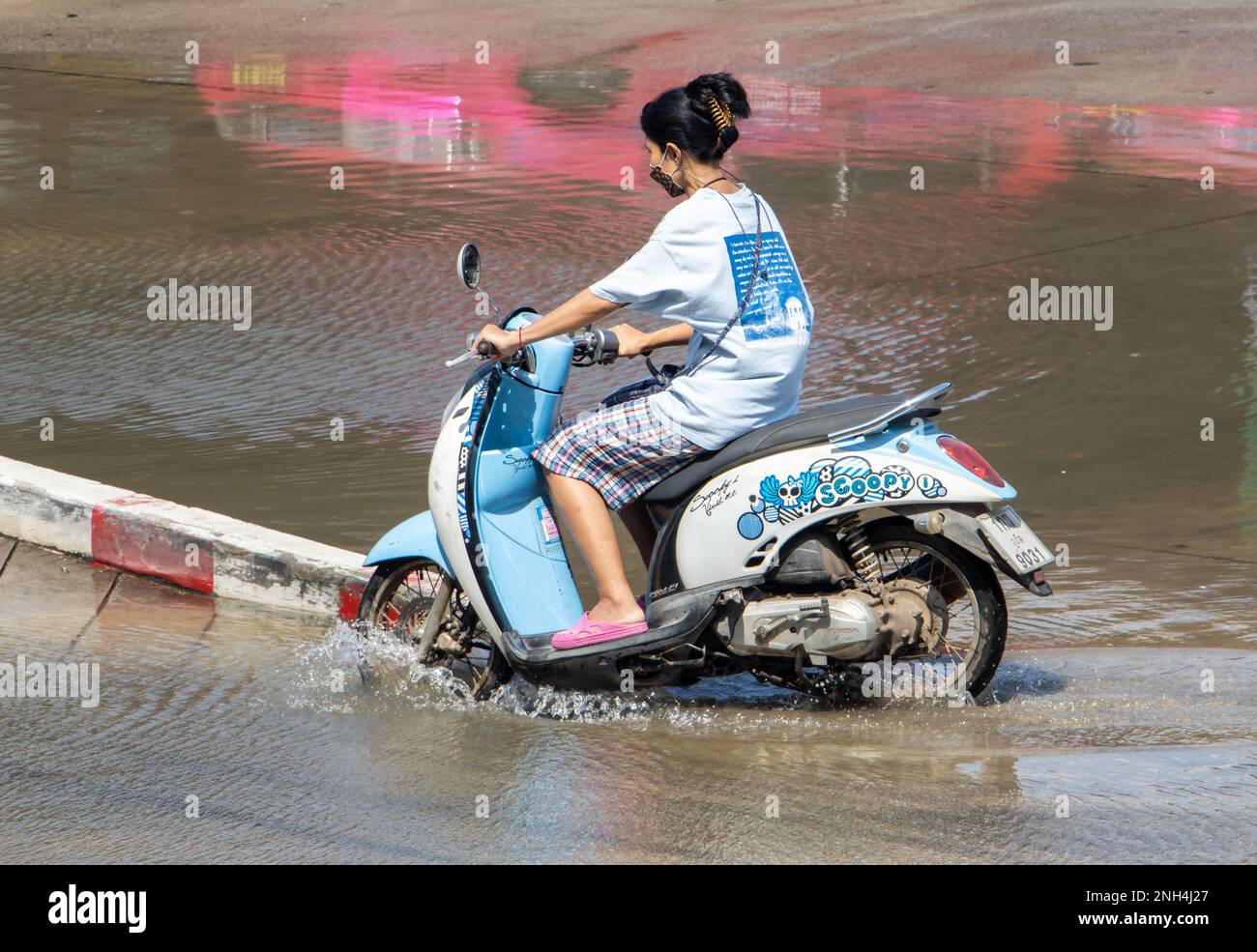 SAMUT PRAKAN, THAILAND, JAN 25 2023, A woman with face mask rides a ...