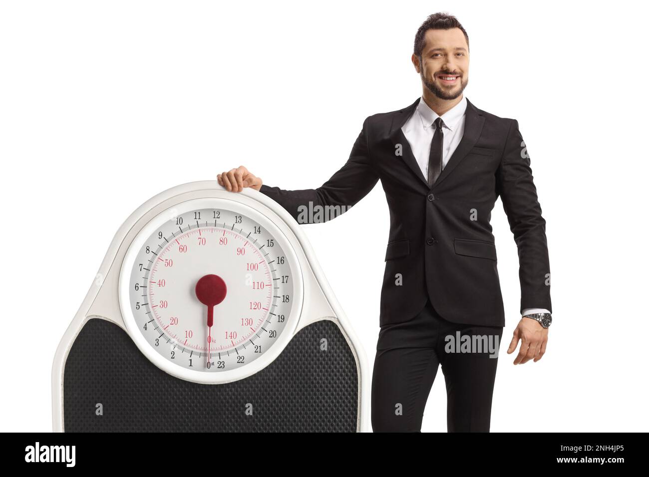 Businessman in a suit and tie leaning on a big weight scale isolated on ...